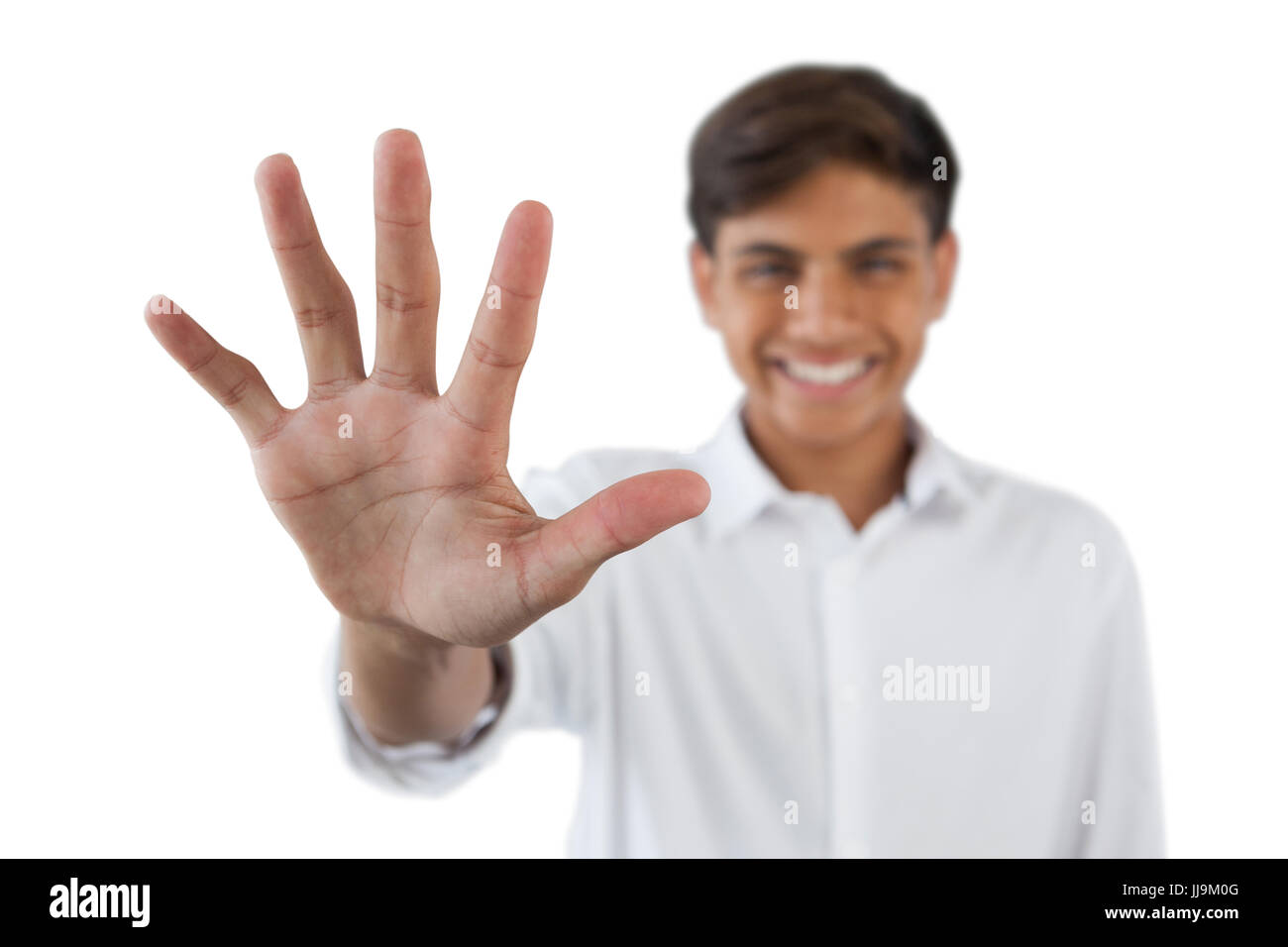 Teenage boy showing stop sign against white background Stock Photo - Alamy