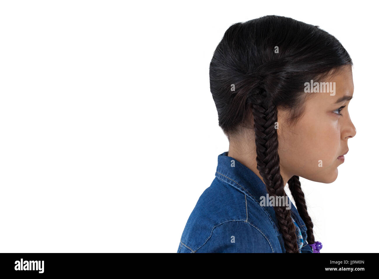 Side view of thoughtful girl standing against white background Stock ...