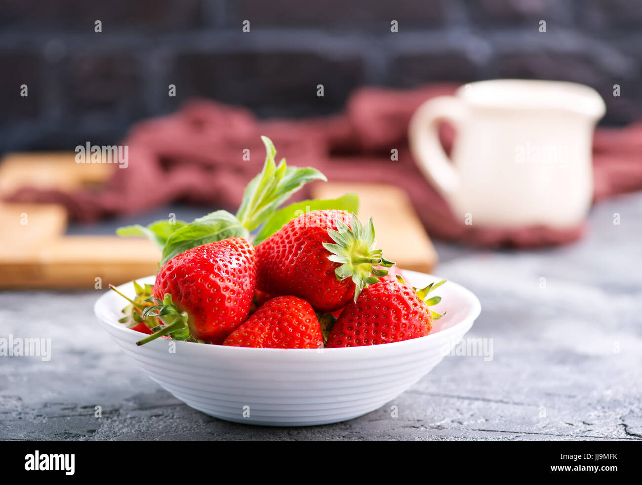 strawberry in bowl and on a table Stock Photo - Alamy