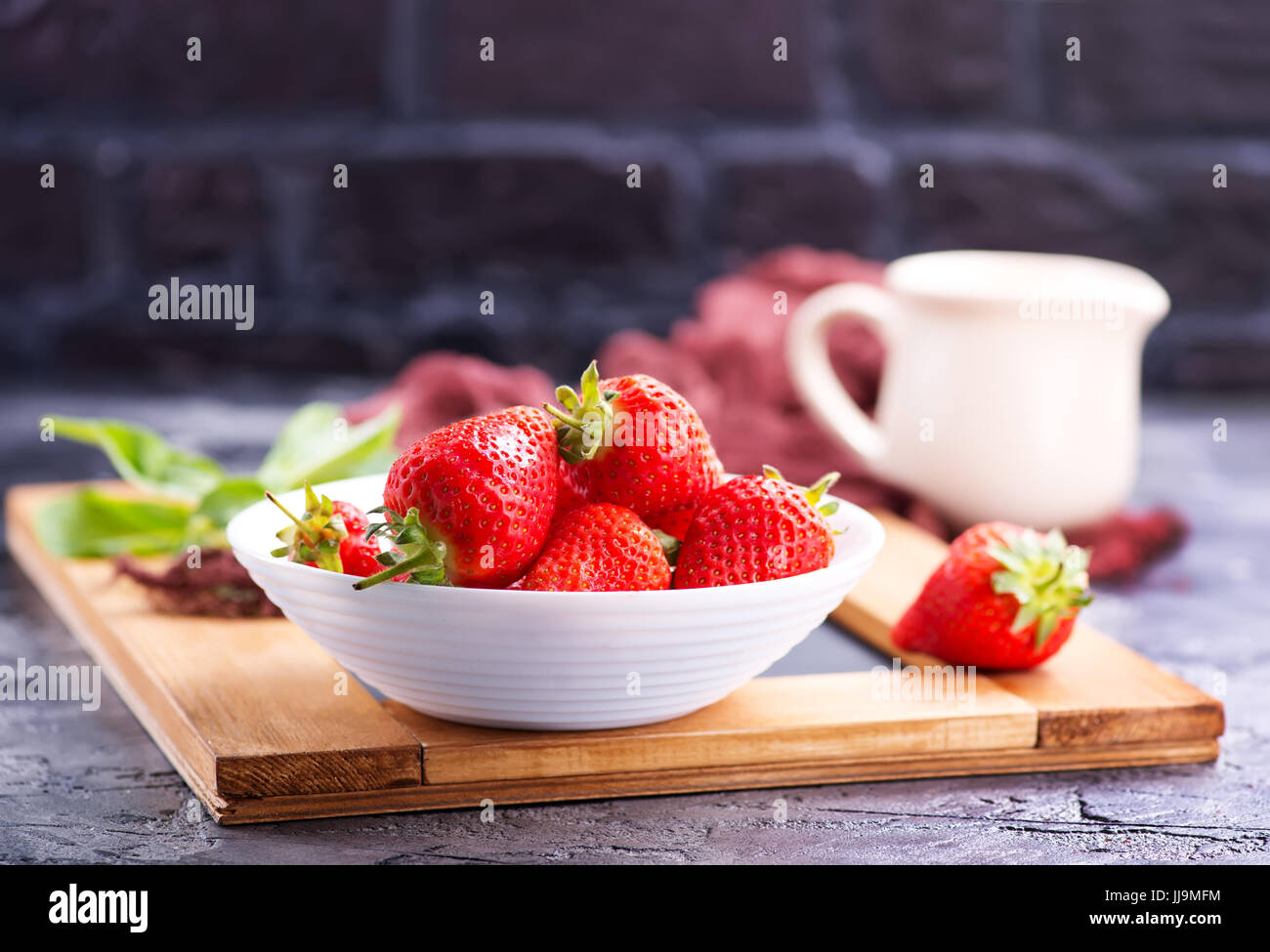 strawberry in bowl and on a table Stock Photo - Alamy
