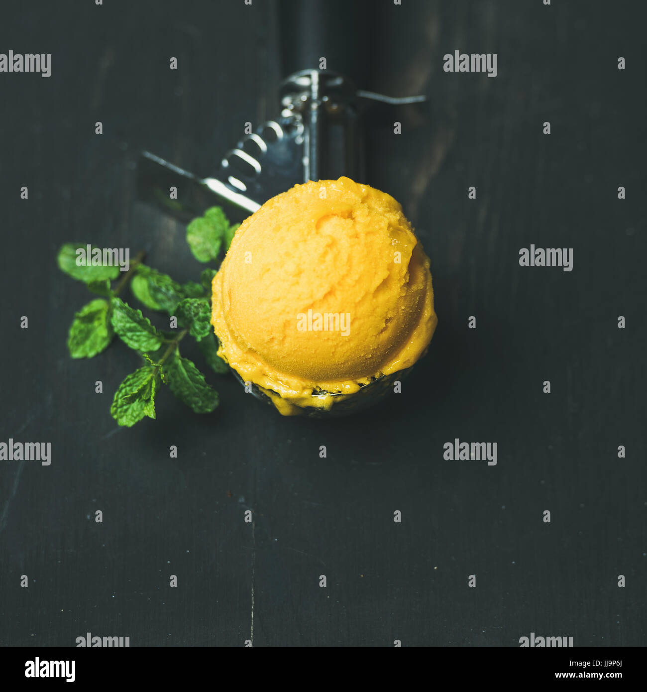Mango sorbet ice cream scoop in scooper, square crop Stock Photo - Alamy