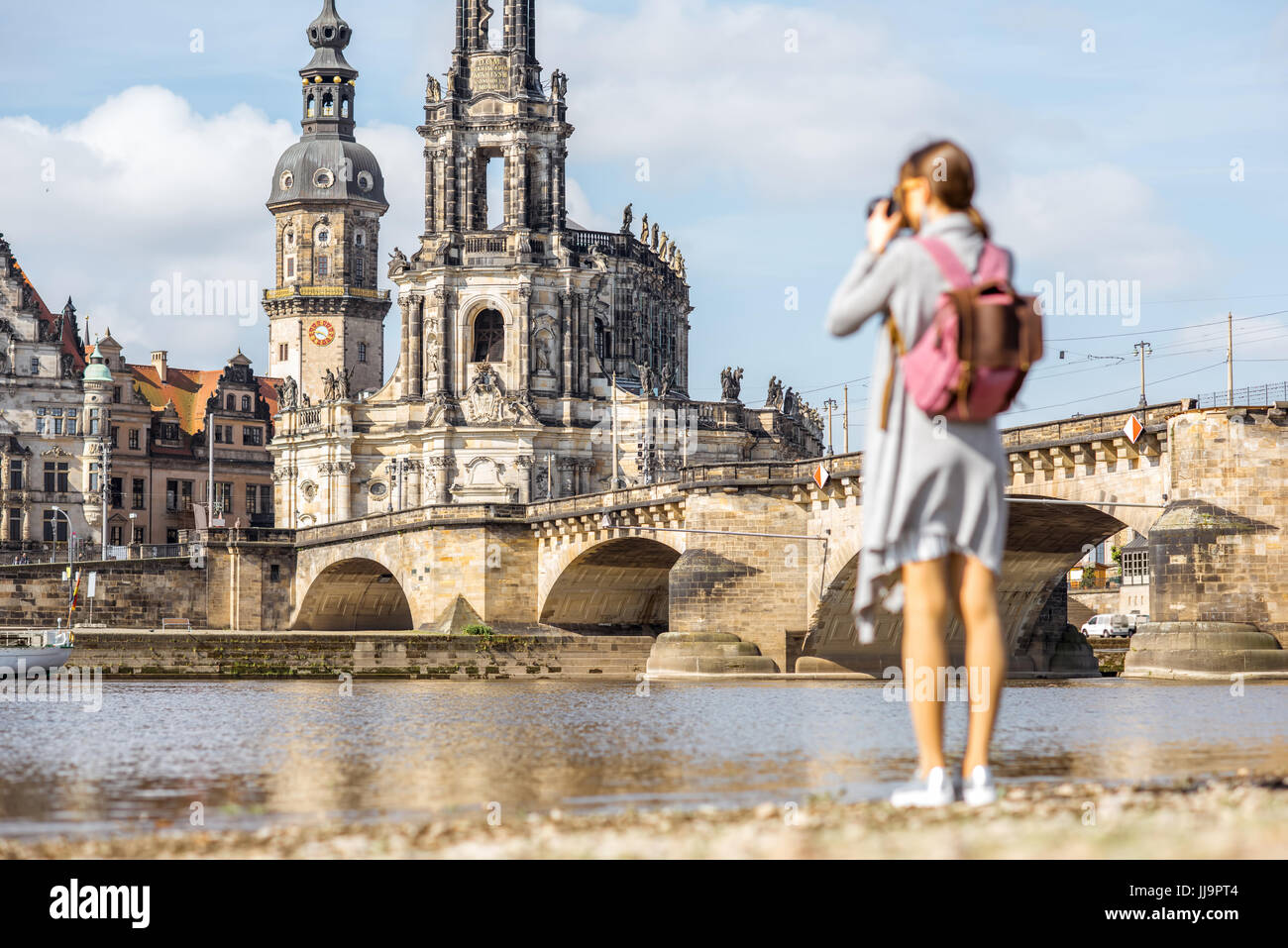 Young woman tourist photographing beautiful view on the riverside of ...