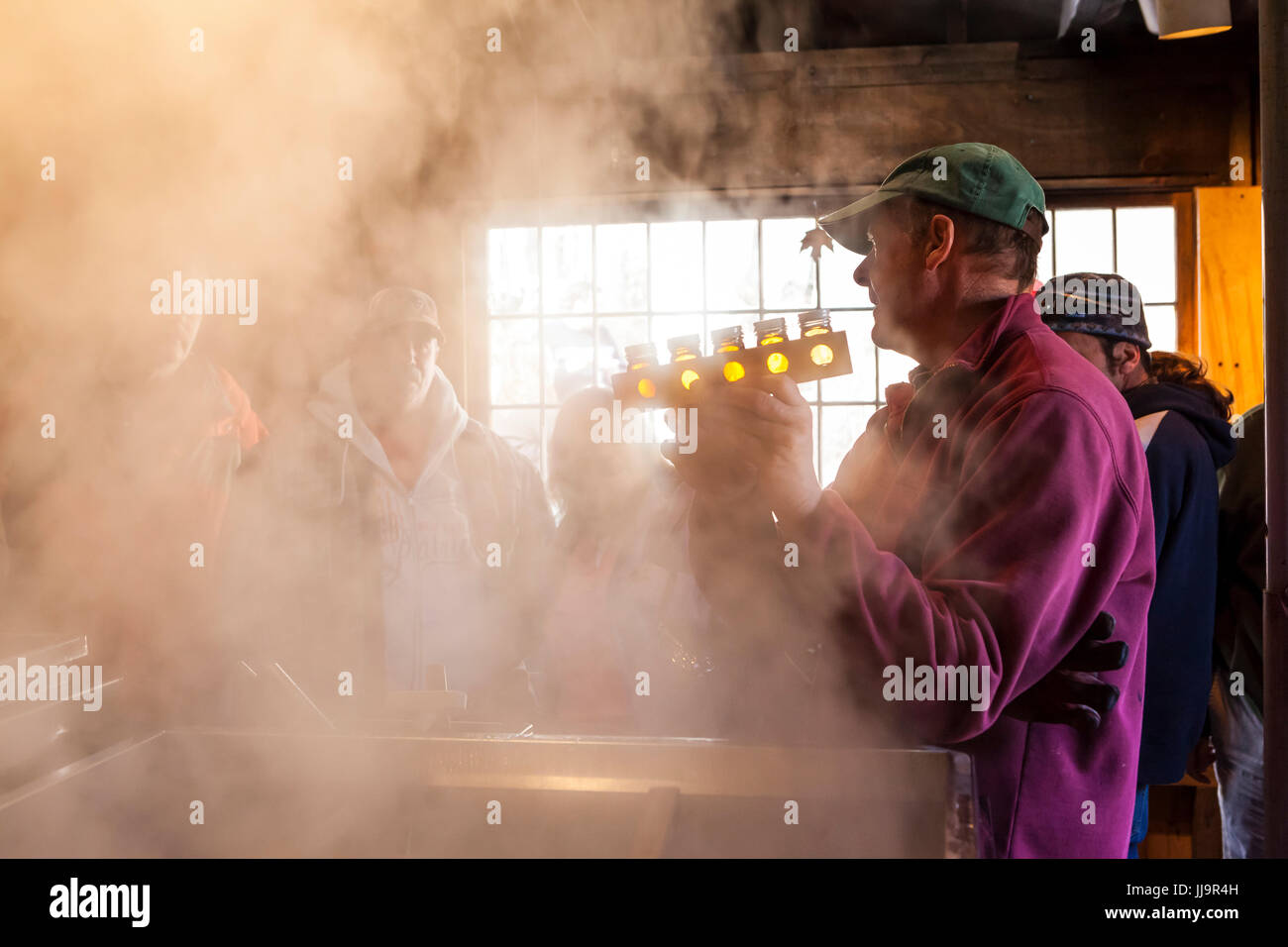A sugarmaker demonstrates the grading of maple syrup to visitors to his ...