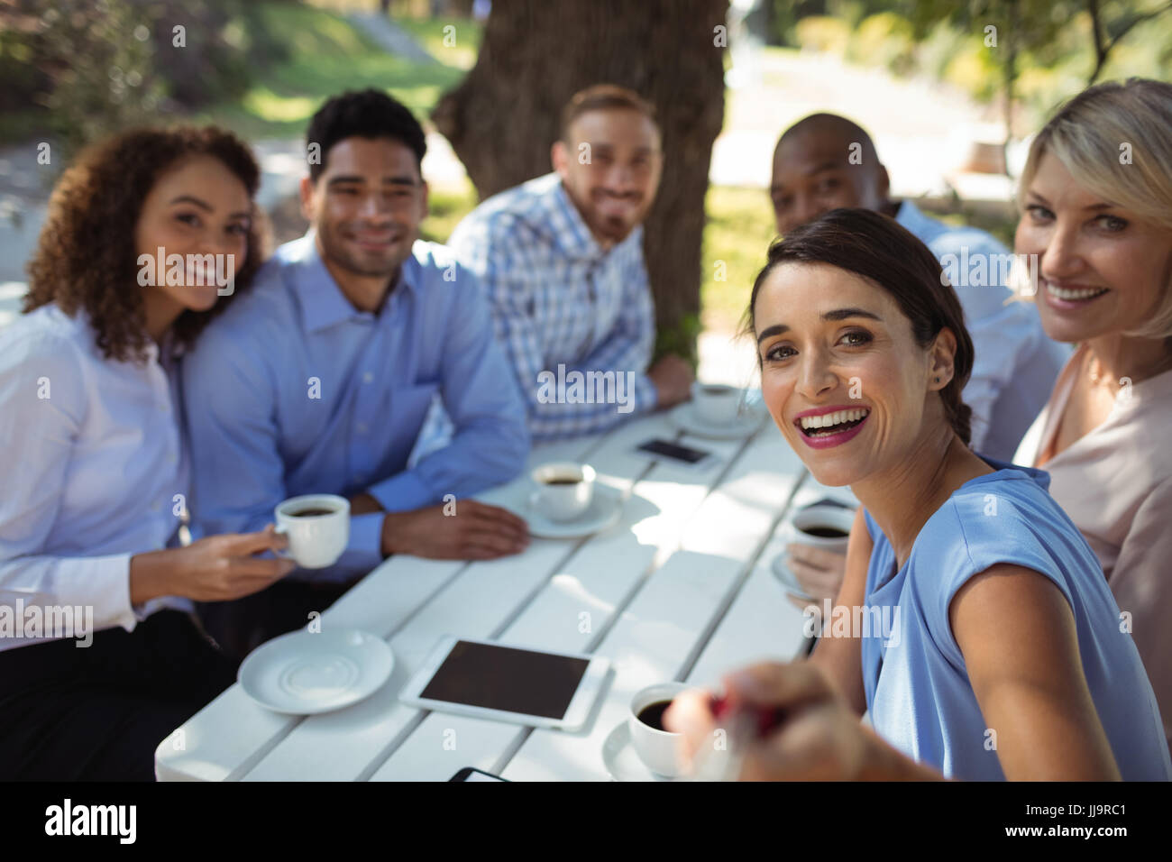 Portrait of group of friends sitting together in outdoor restaurant ...