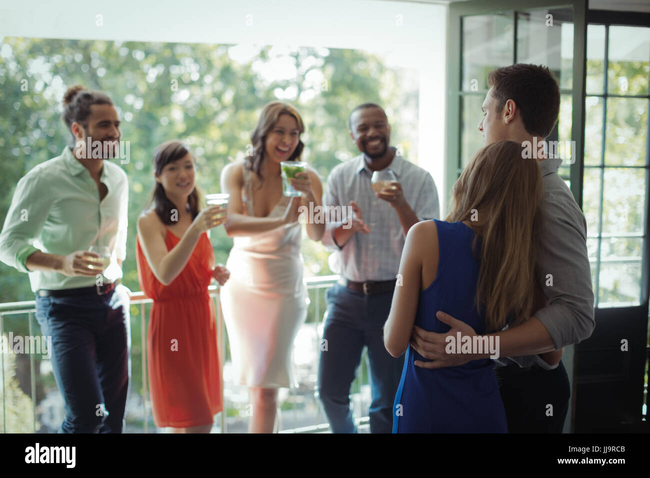 Group of friends interacting with each other while having cocktail ...