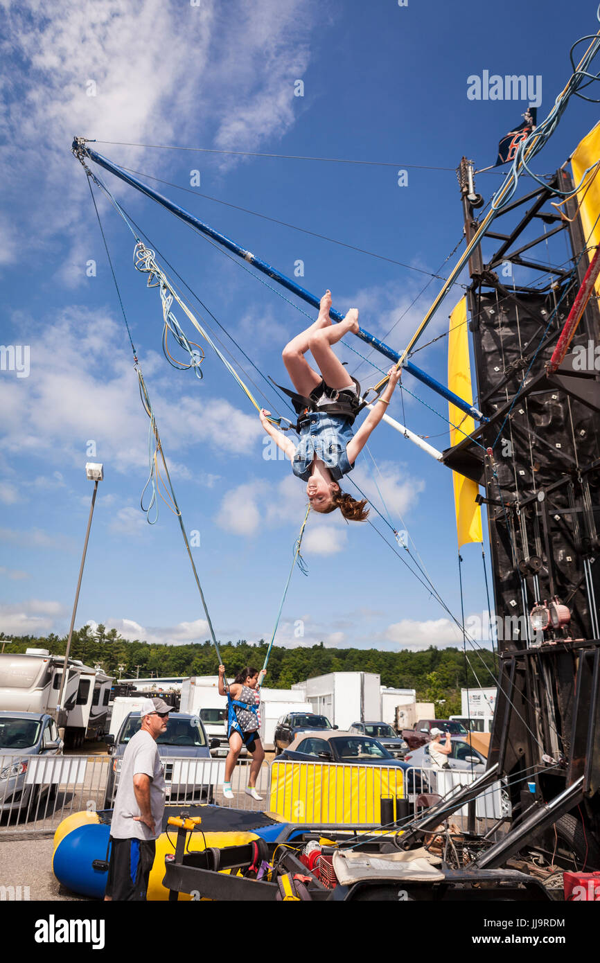 A young woman does a flip mid-air during pre-race activities set up at ...