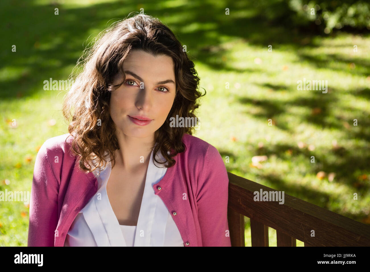 Woman sitting on bench in garden on a sunny day Stock Photo - Alamy