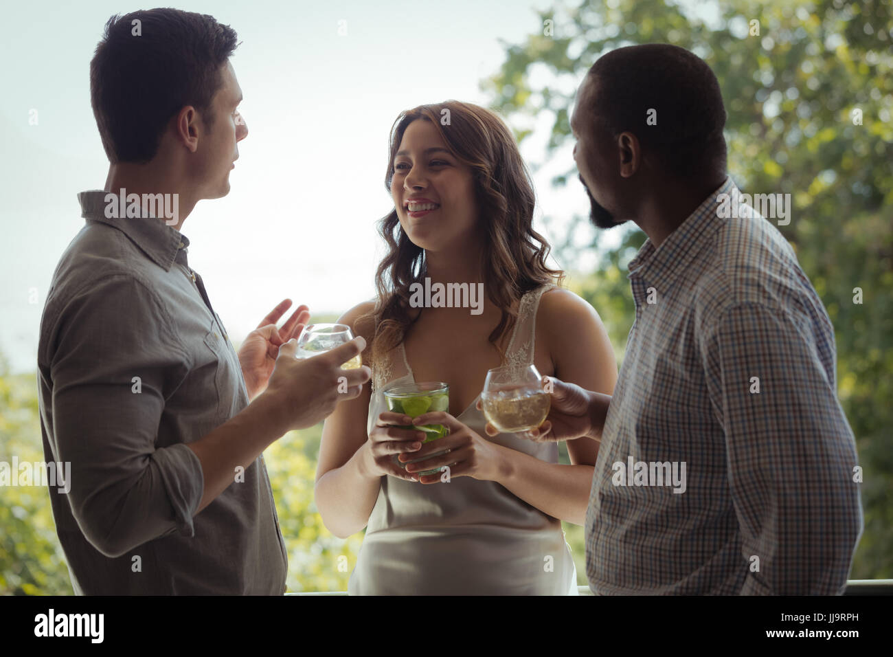 Group of friends interacting with each other while having cocktail ...