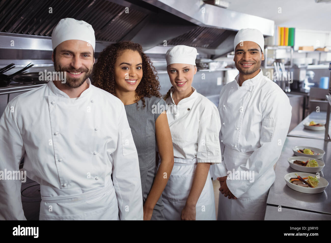 Portrait of restaurant manager with his kitchen staff in the commercial ...