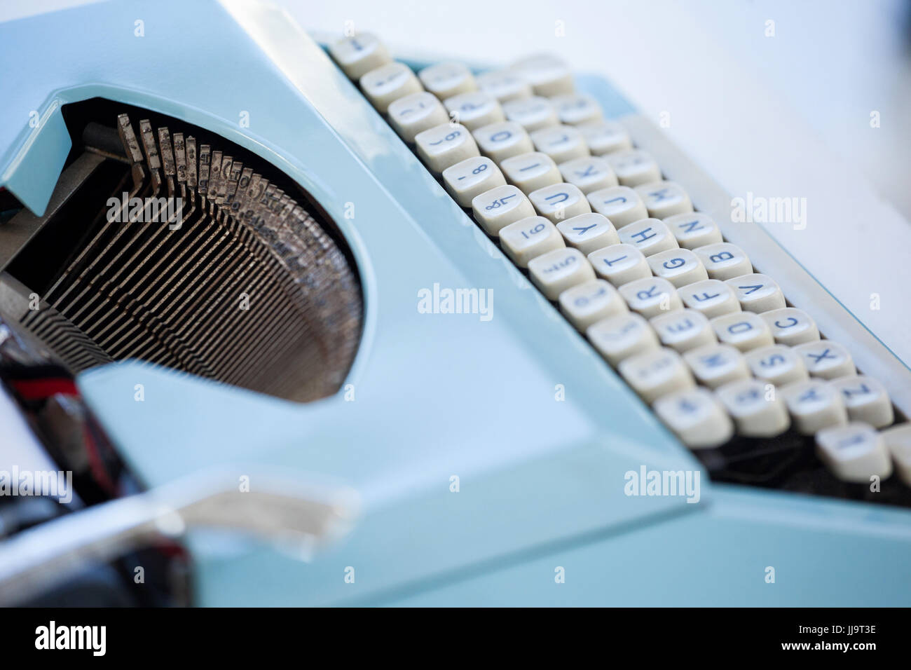 Close up of blue typewriter at desk Stock Photo - Alamy