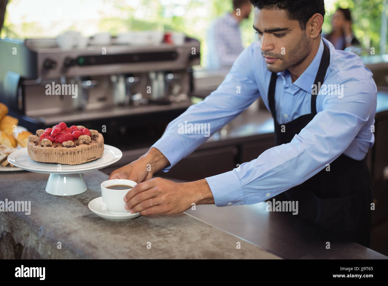 Waiter serving coffee at counter in commercial kitchen Stock Photo - Alamy