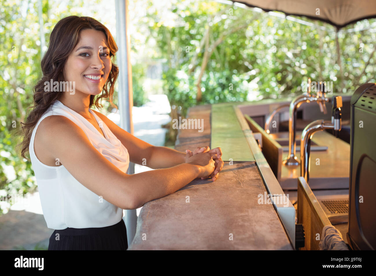 Portrait of woman standing at counter in restaurant Stock Photo - Alamy