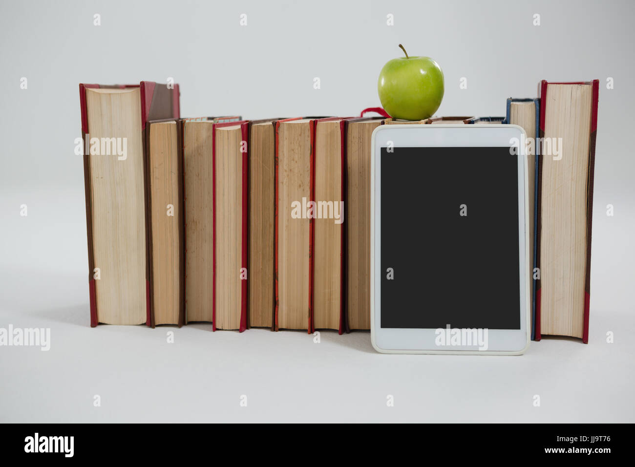 Apple, digital tablet and books arranged on white background Stock ...