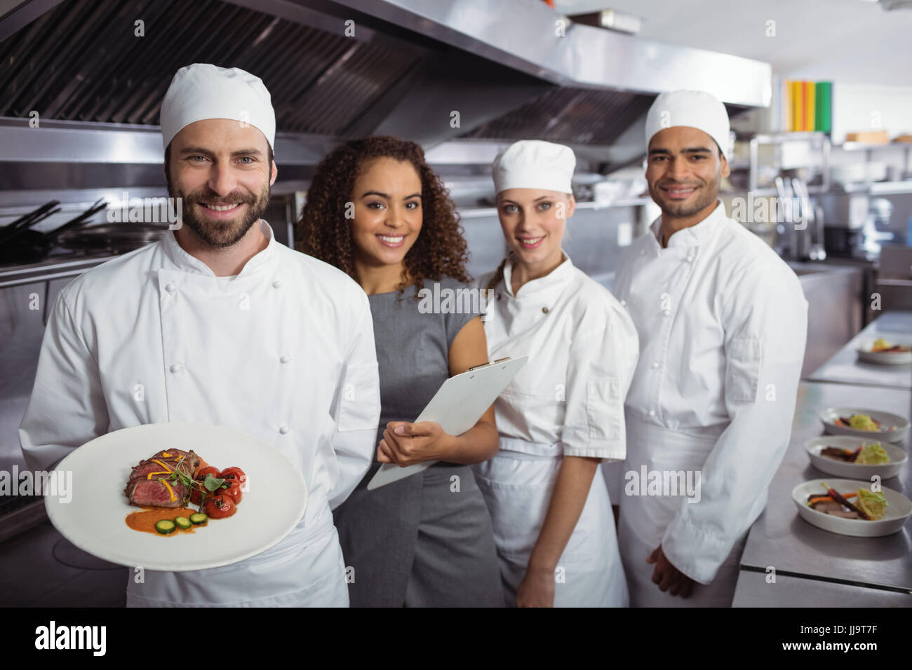 Portrait of restaurant manager with his kitchen staff in the commercial ...