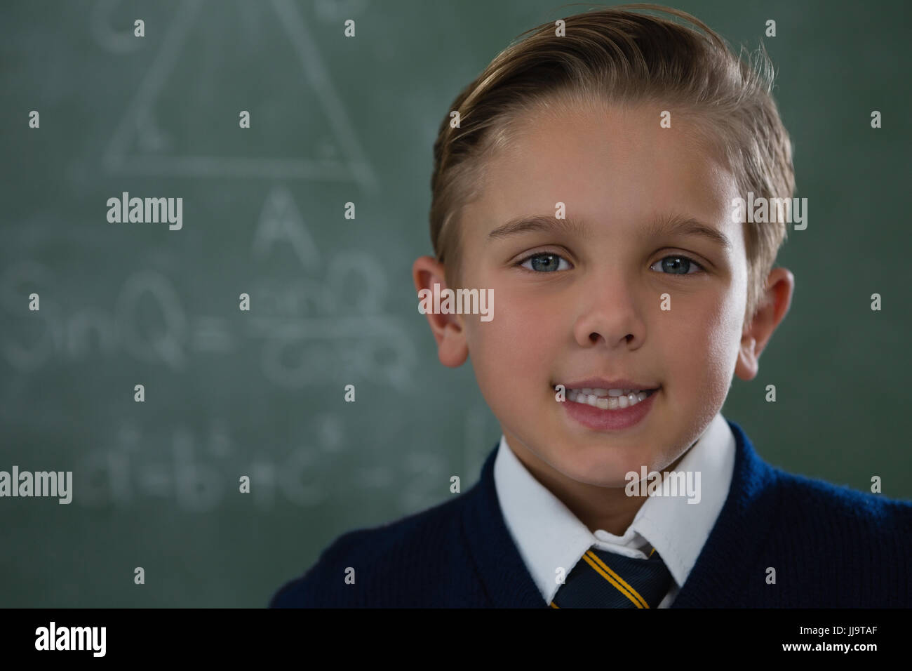 Little boy smiling in front of chalkboard Stock Photo - Alamy