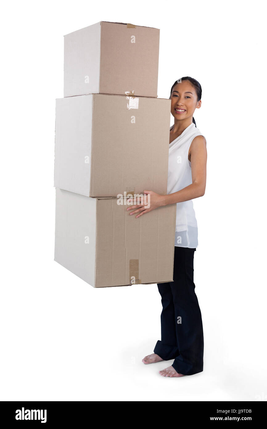 Portrait of businesswoman carrying stack of cardboard boxes while ...