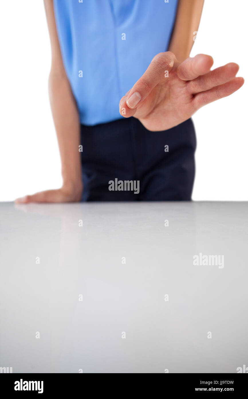 Businesswoman showing something standing by table against white ...