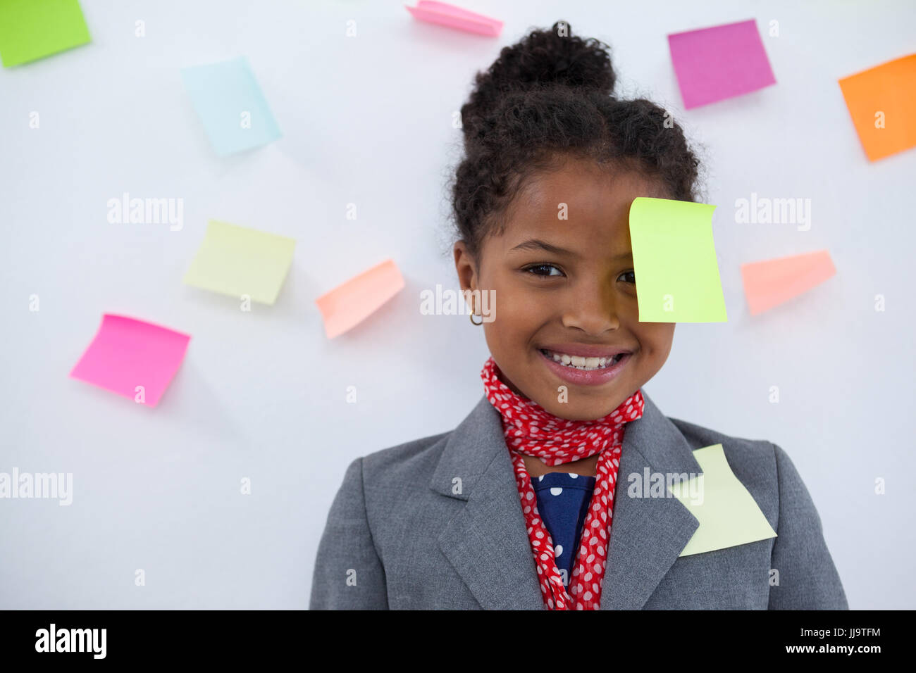 Portrait of smiling businesswoman with sticky notes stuck on head ...