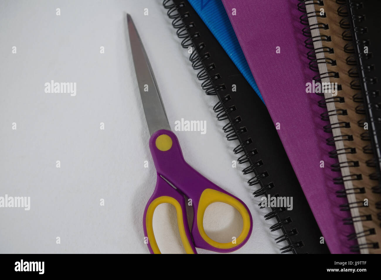 Close-up of scissors and spiral books on white background Stock Photo ...