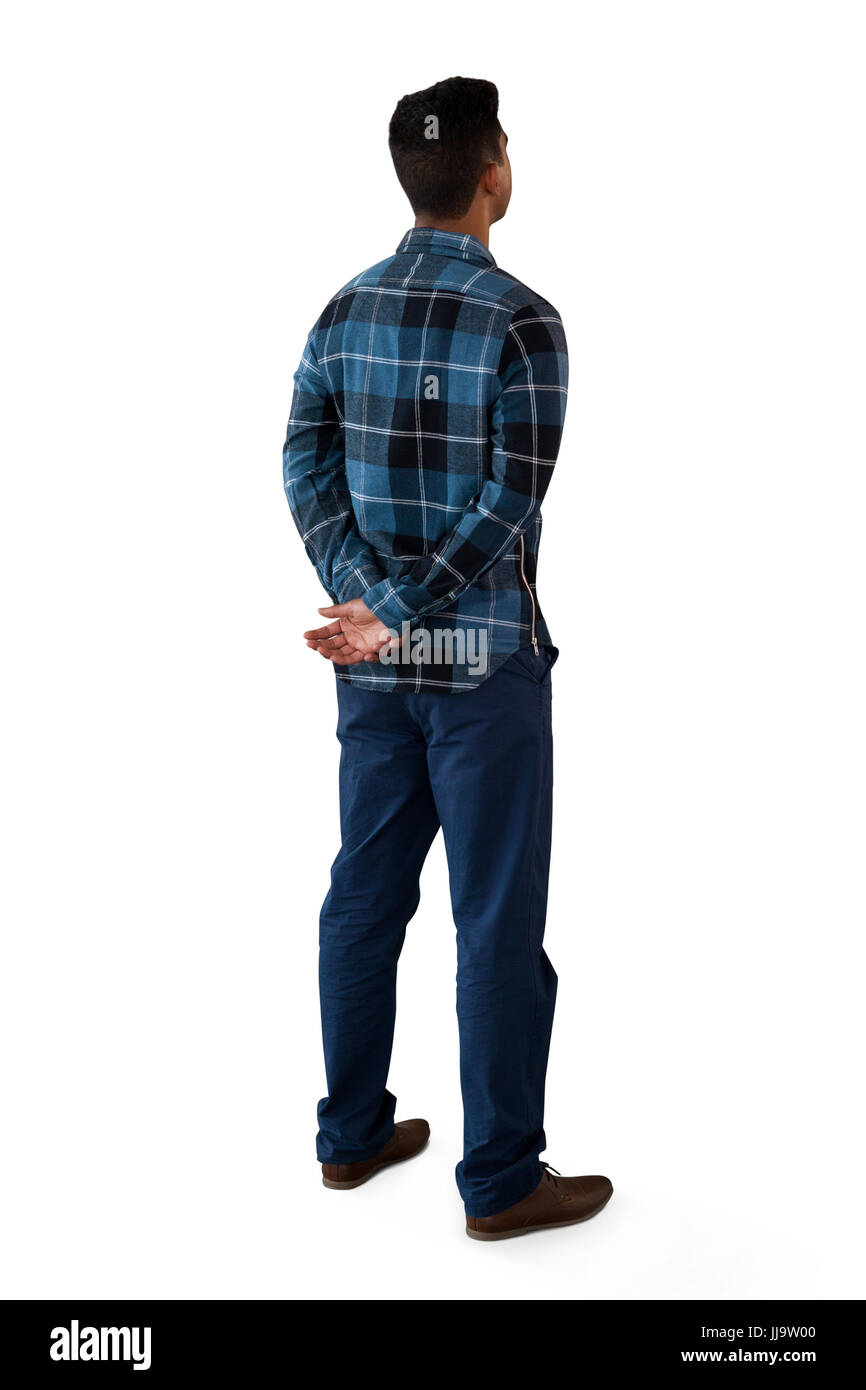 Rear view of man with hands behind back standing against white ...