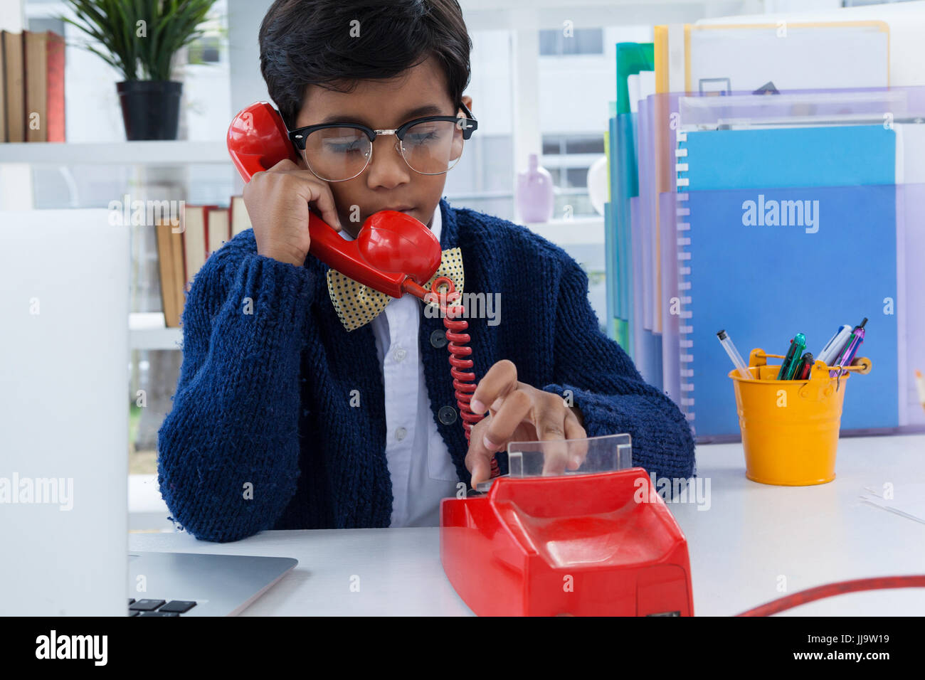 Businessman using land line phone at desk in office Stock Photo - Alamy