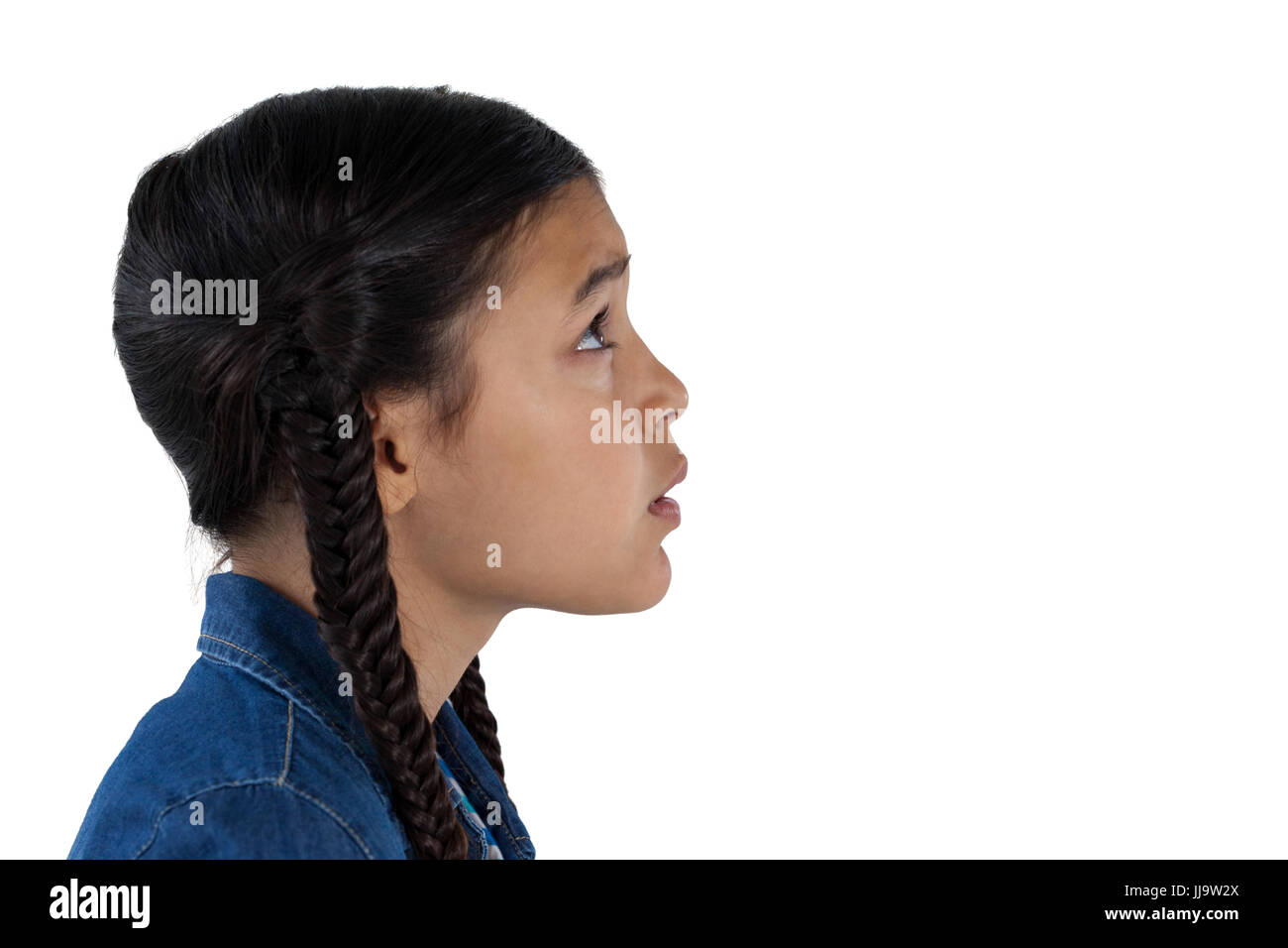 Side view of thoughtful girl standing against white background Stock ...
