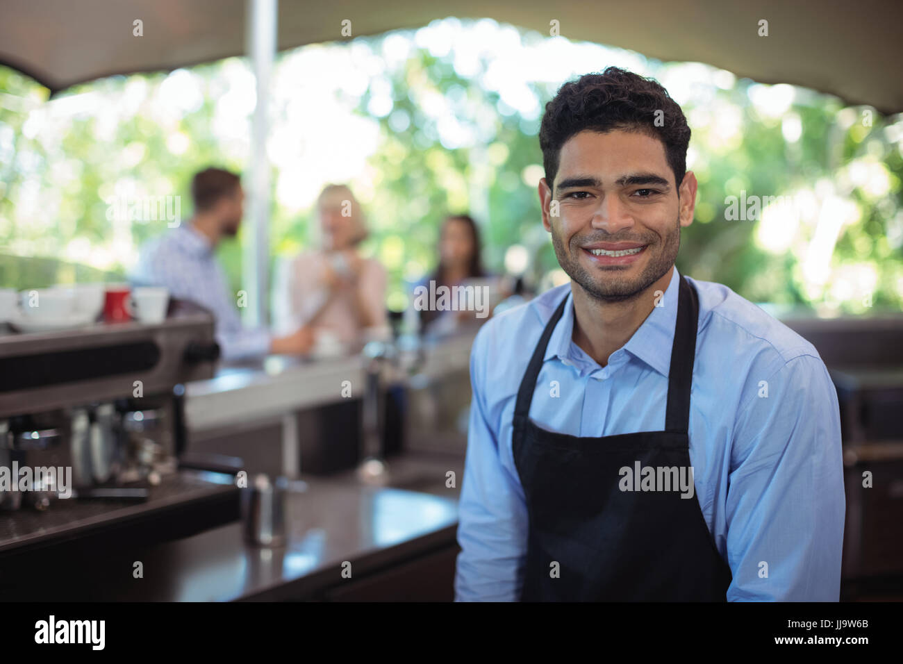 Portrait of smiling waiter at counter in restaurant Stock Photo - Alamy