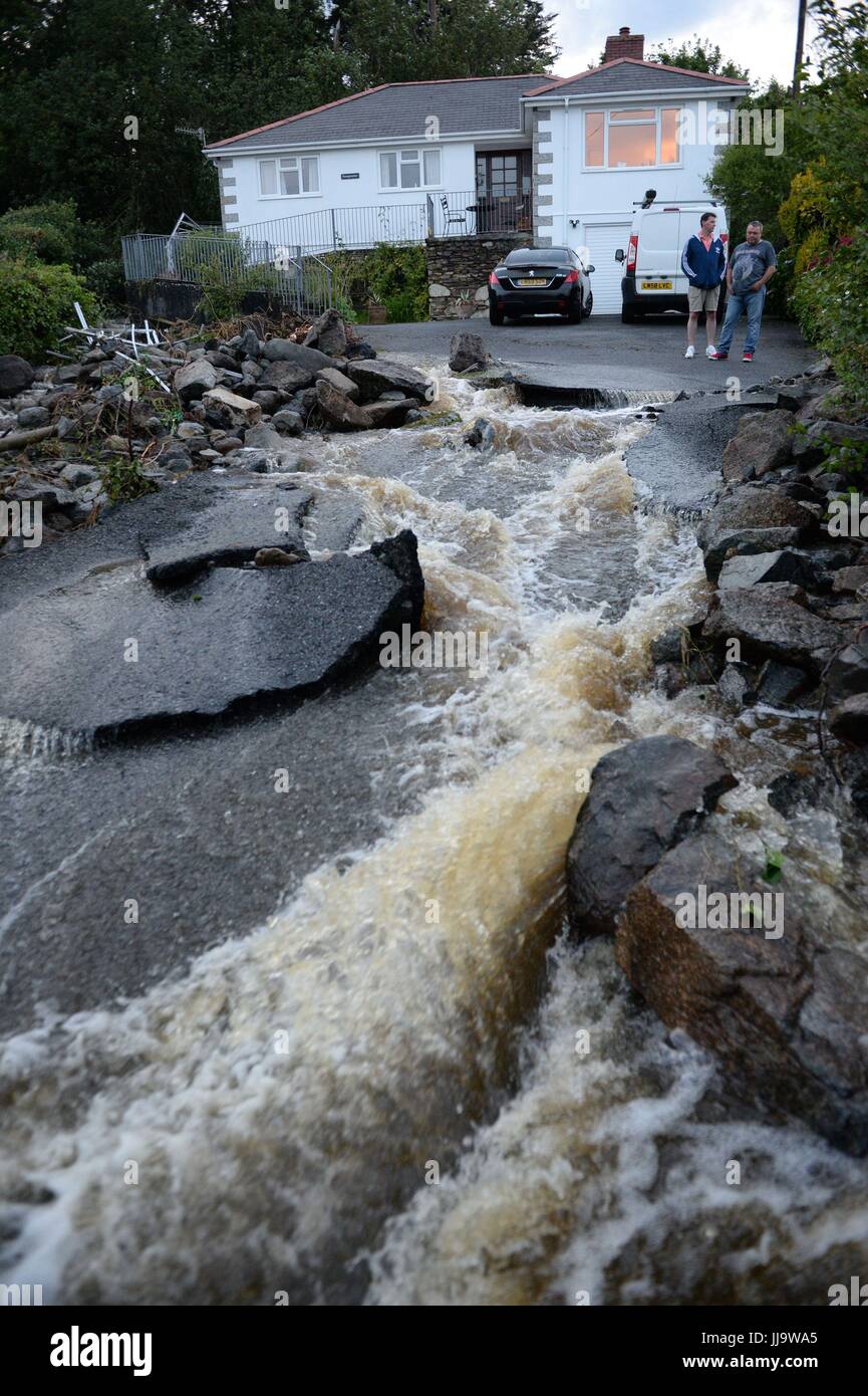 A driveway is lifted caused by water from flash flooding in the coastal ...