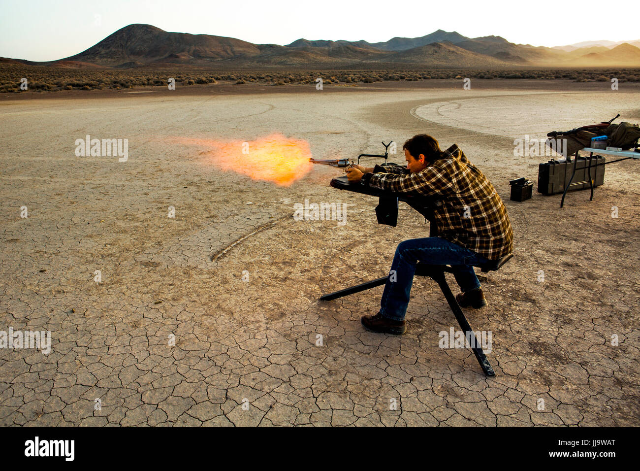 A man fires his revolver from a shooting stand in the High Sierras ...