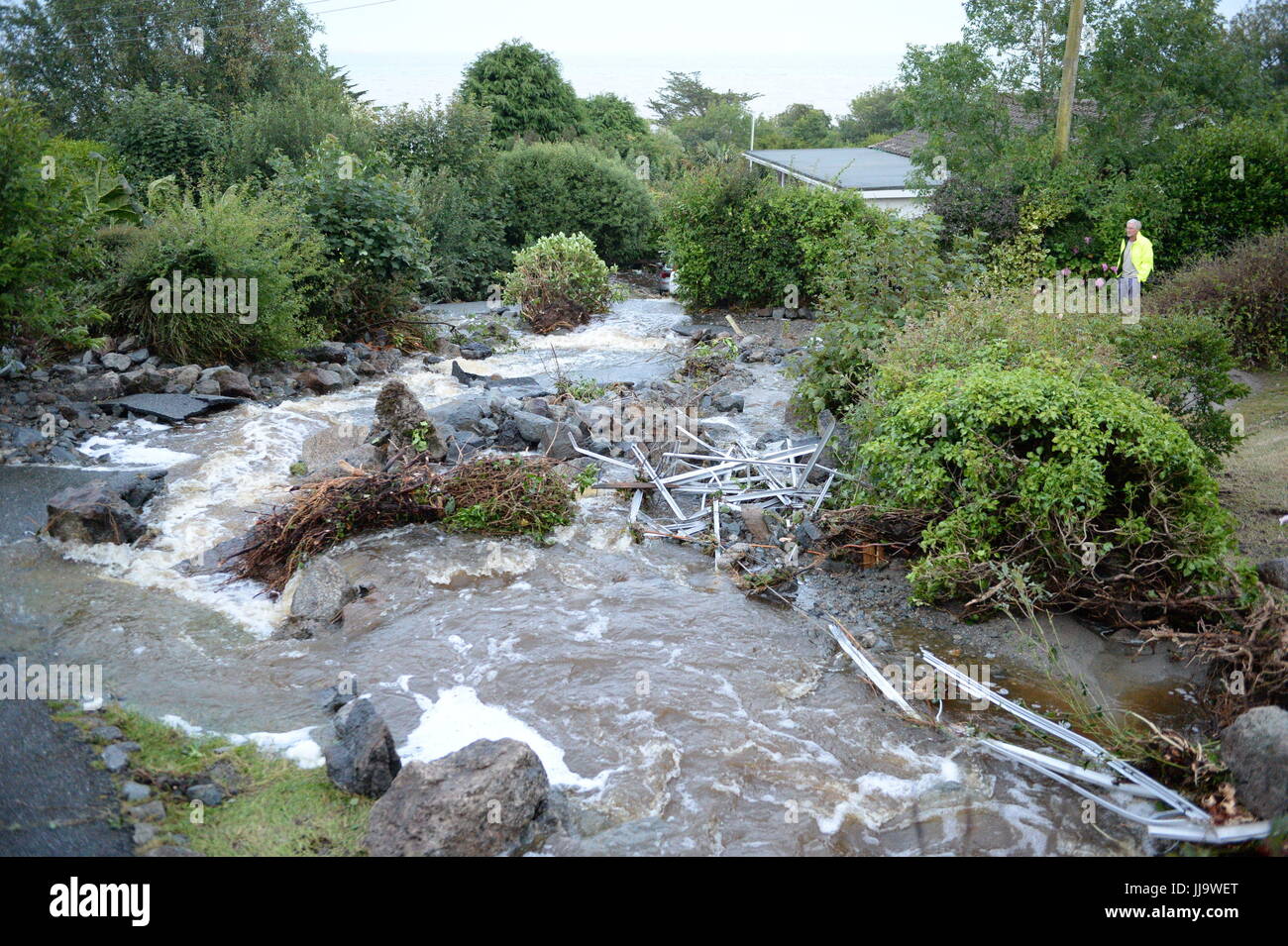 Rocks and debris cover a path after a brook burst its banks following ...