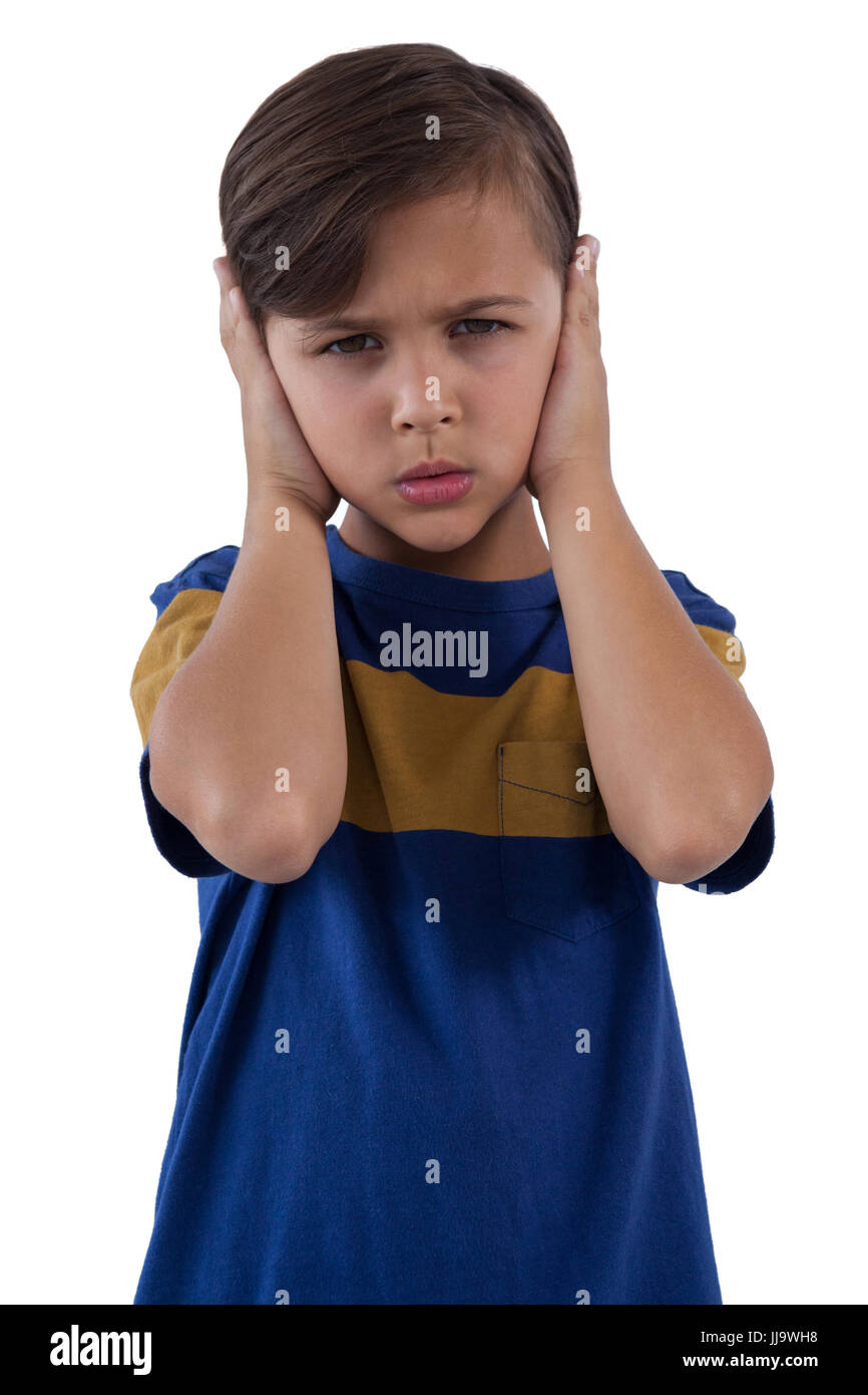 Portrait of cute boy covering his ears against white background Stock ...