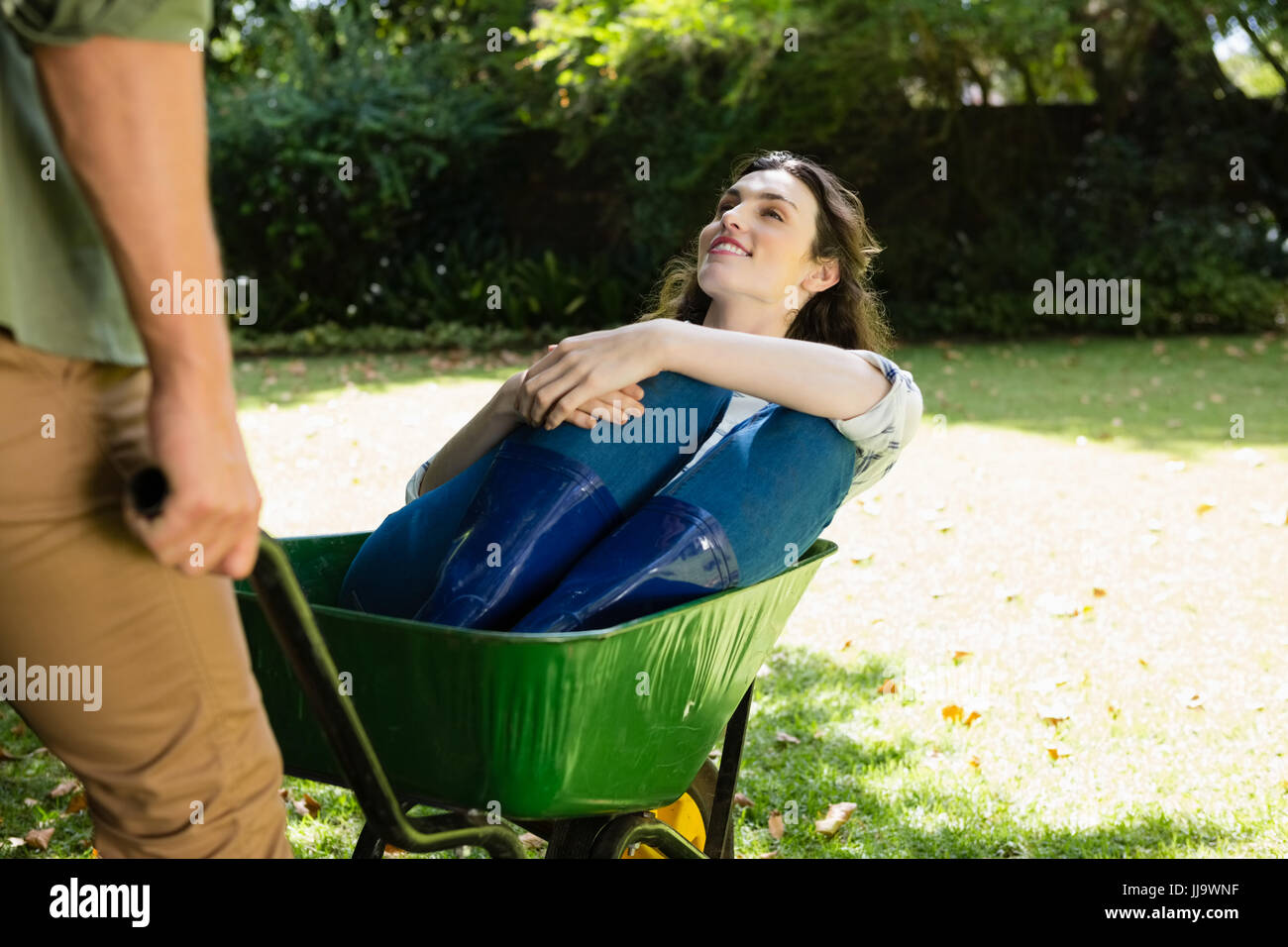 Man interacting with woman while pushing wheelbarrow in garden on a ...