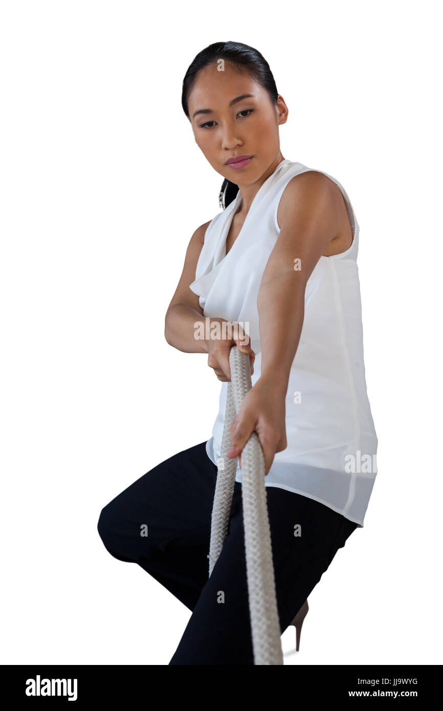 Woman looking away while pulling rope against white background Stock ...