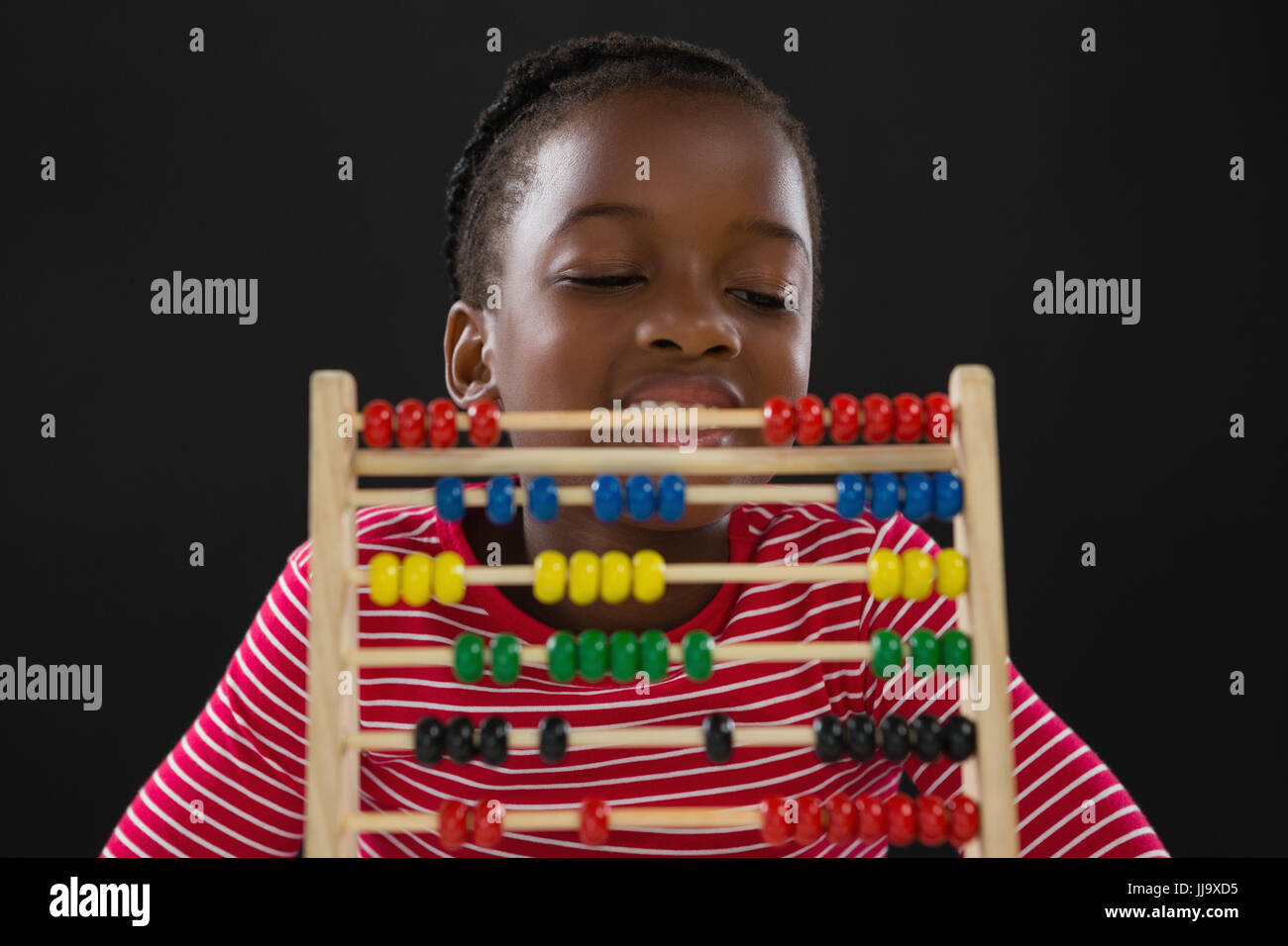 Cute little girl counting on abacus against black background Stock ...