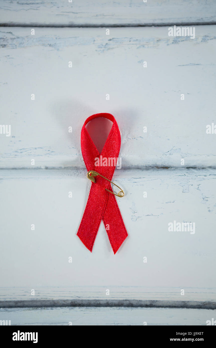 Overhead view of red AIDS awareness ribbon on white wooden table Stock ...