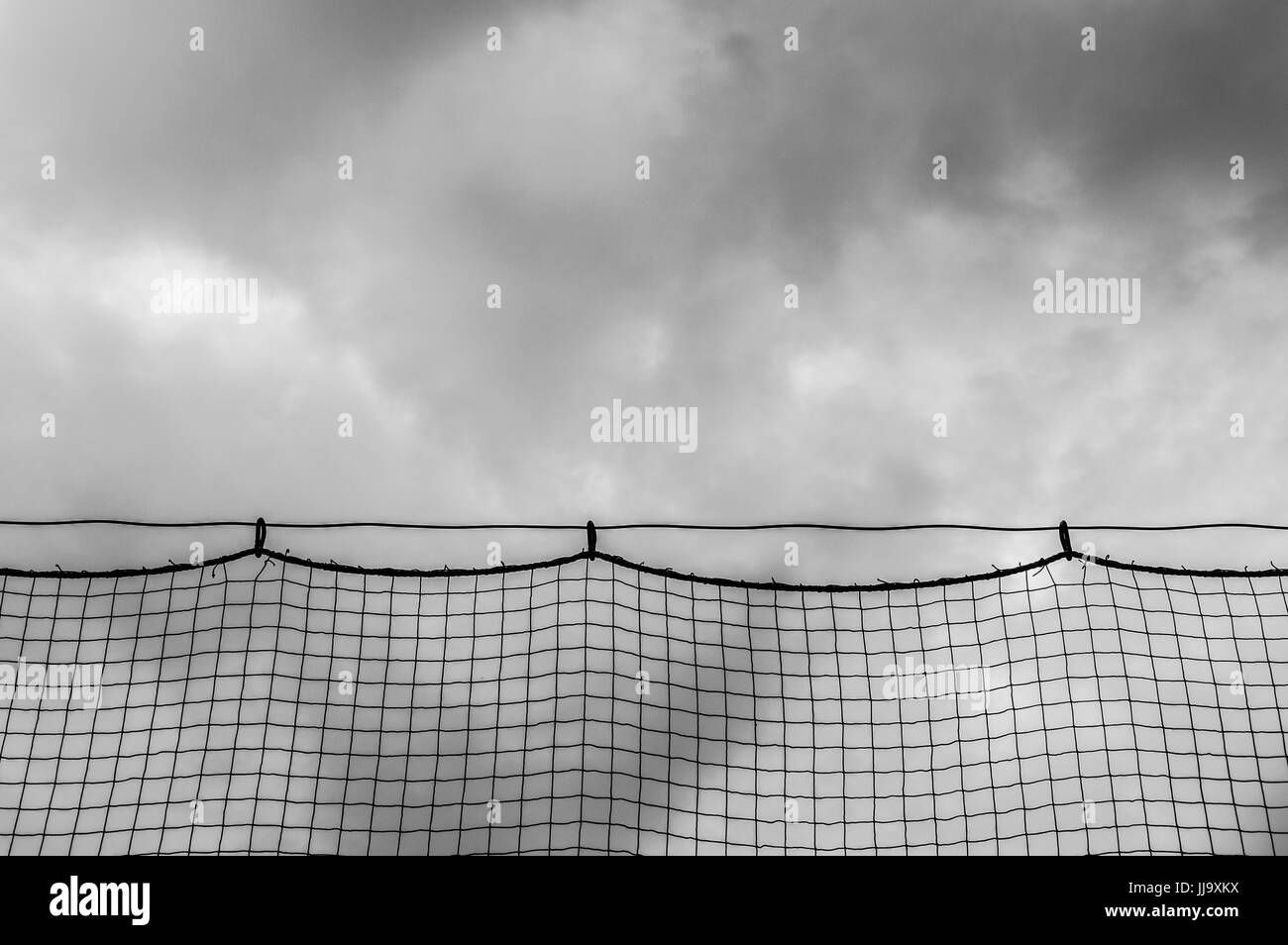 ominous dark storm clouds view from behind baseball field netting Stock ...