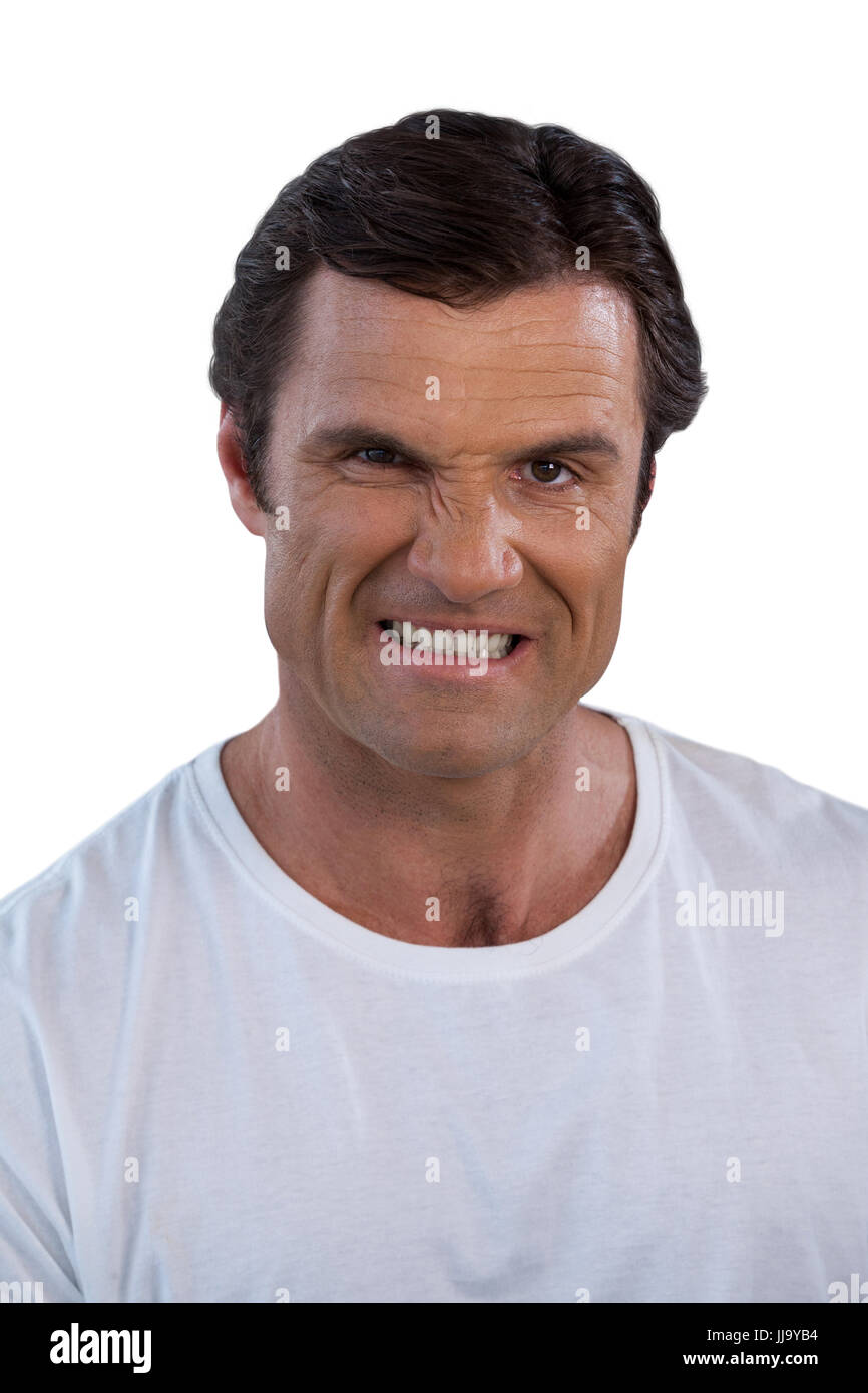 Portrait of mature man clenching teeth against white background Stock ...