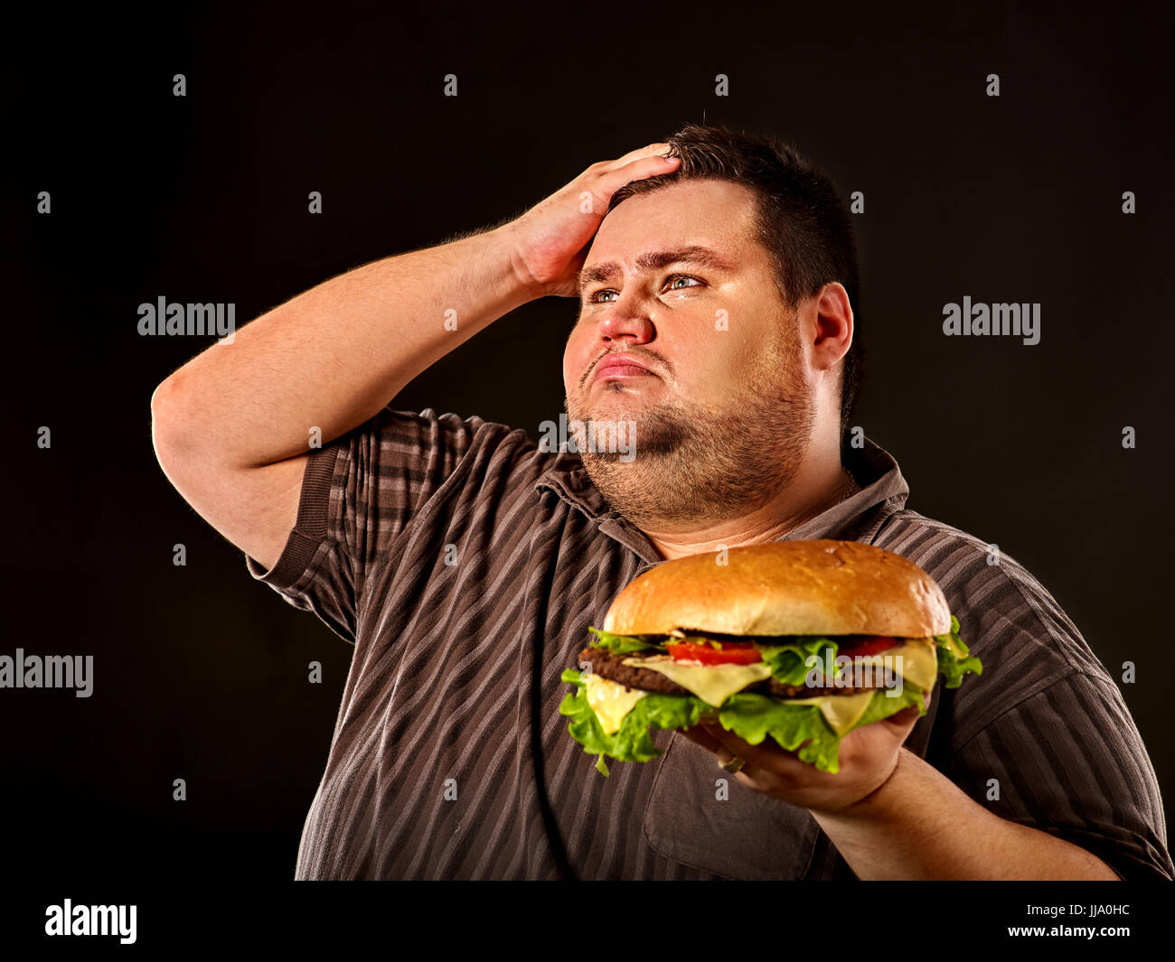 Fat man eating fast food hamberger. Breakfast for overweight person ...