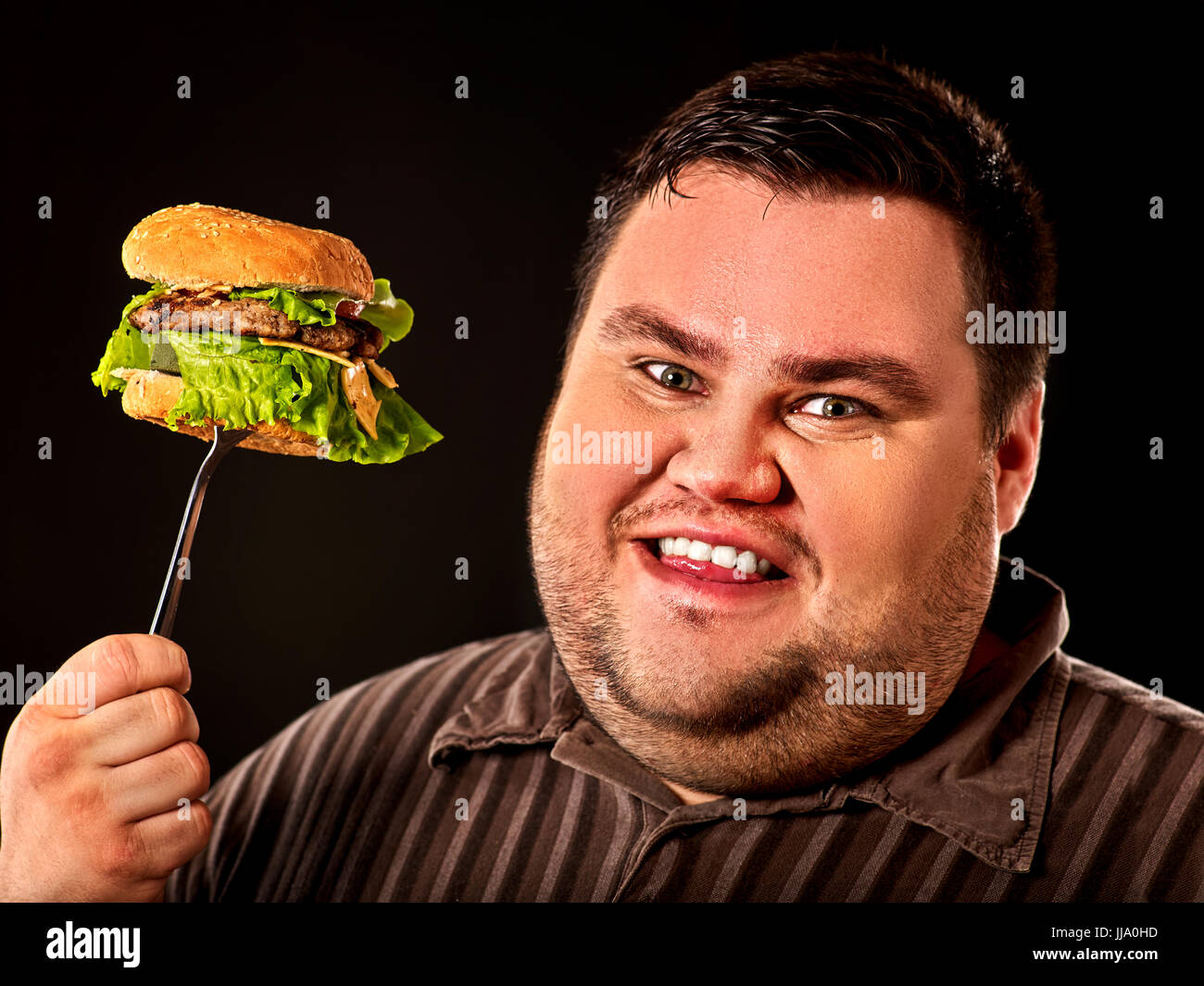 Fat man eating fast food hamberger. Breakfast for overweight person ...