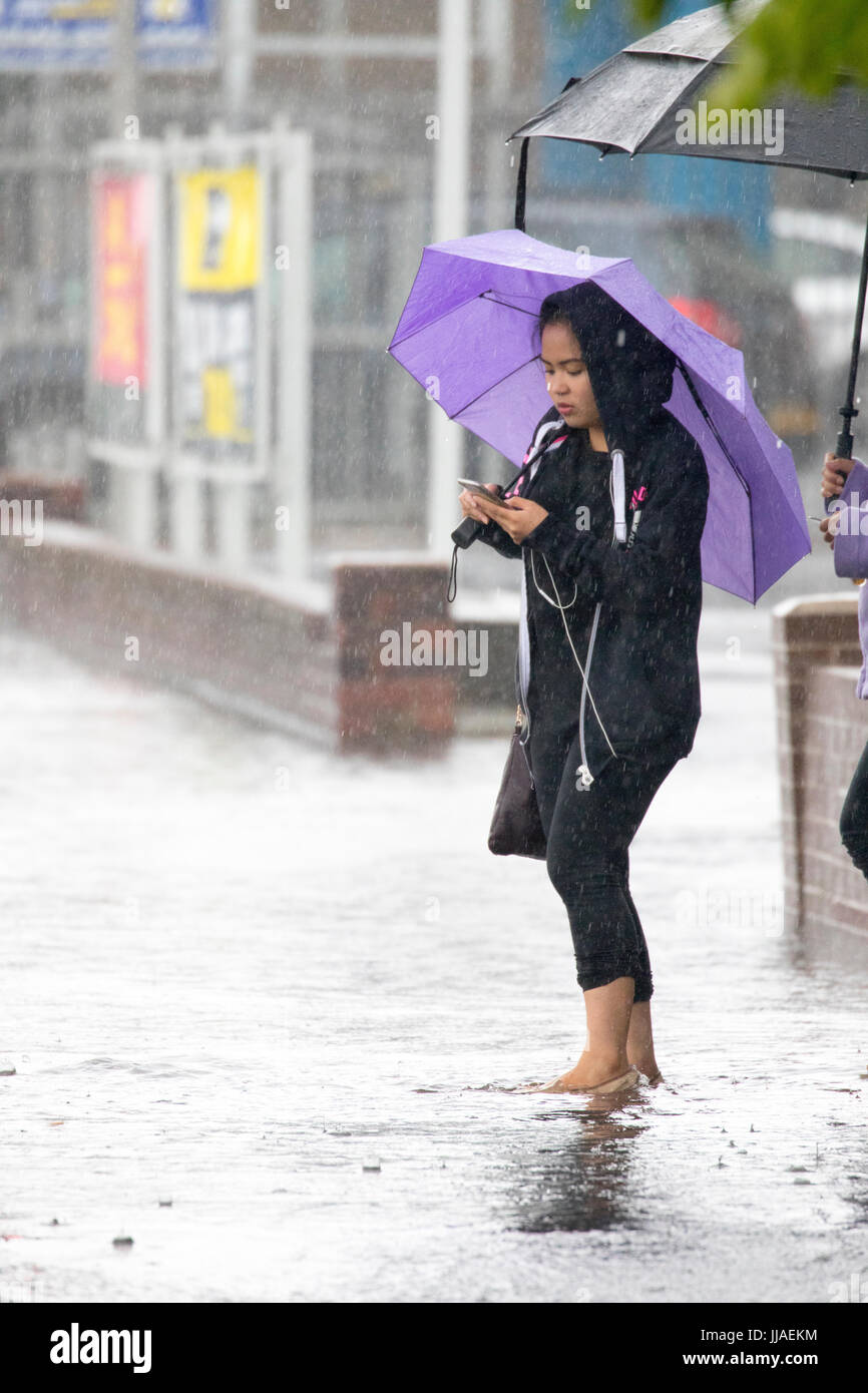A woman walks through flash flooding water on her way home after heavy ...