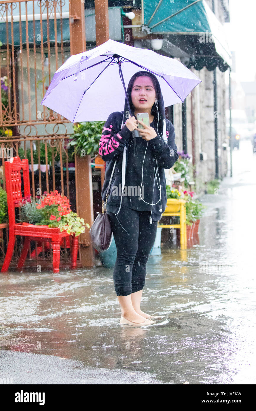 A woman walks through flash flooding water on her way home after heavy ...