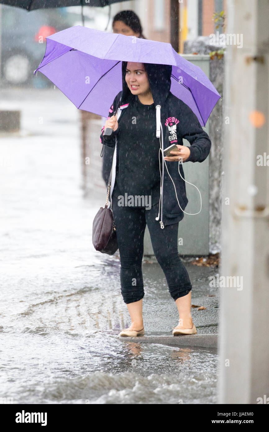 A woman walks through flash flooding water on her way home after heavy ...