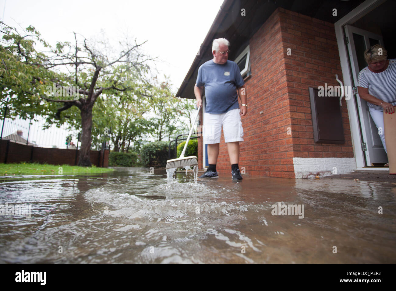 Elderly person trying to keep flash flood water out his house by ...