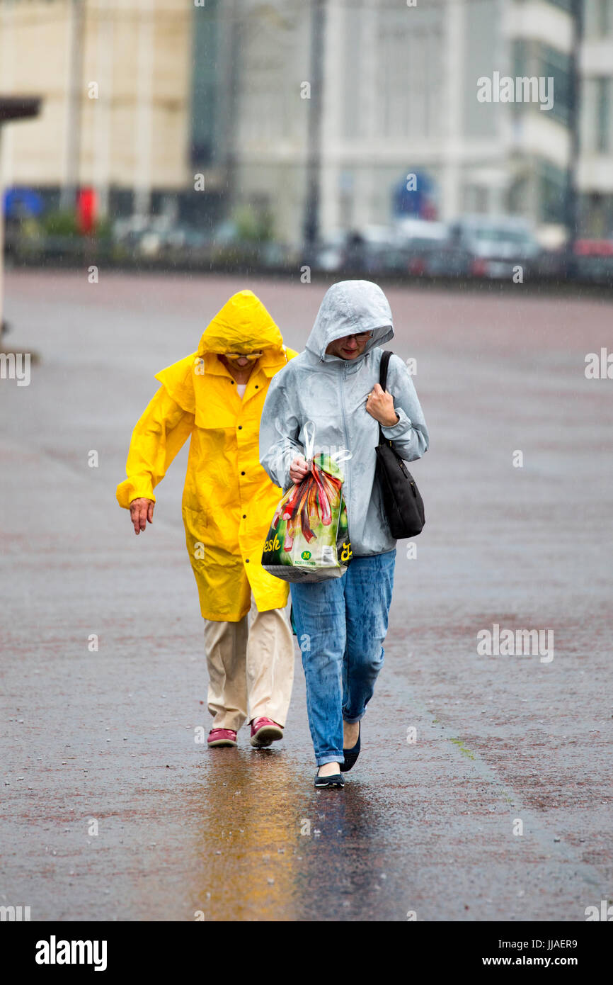 A couple in rain weather clothing braving the torrential rain on the ...