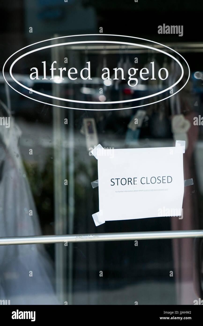 A "Store Closed" sign outside of a Alfred Angelo Bridal retail store ...