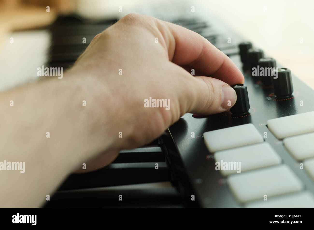 Man's hand sets the synthesizer. Side view Stock Photo - Alamy