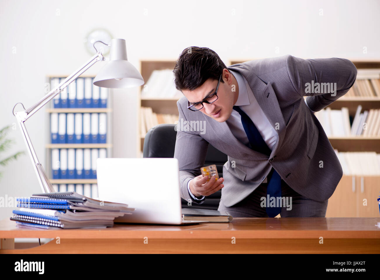 Businessman feeling pain in the office Stock Photo - Alamy