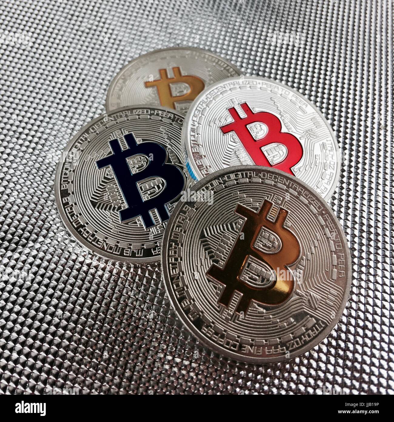 Digital currency physical silver bitcoin coins. Red, blue and yellow ...