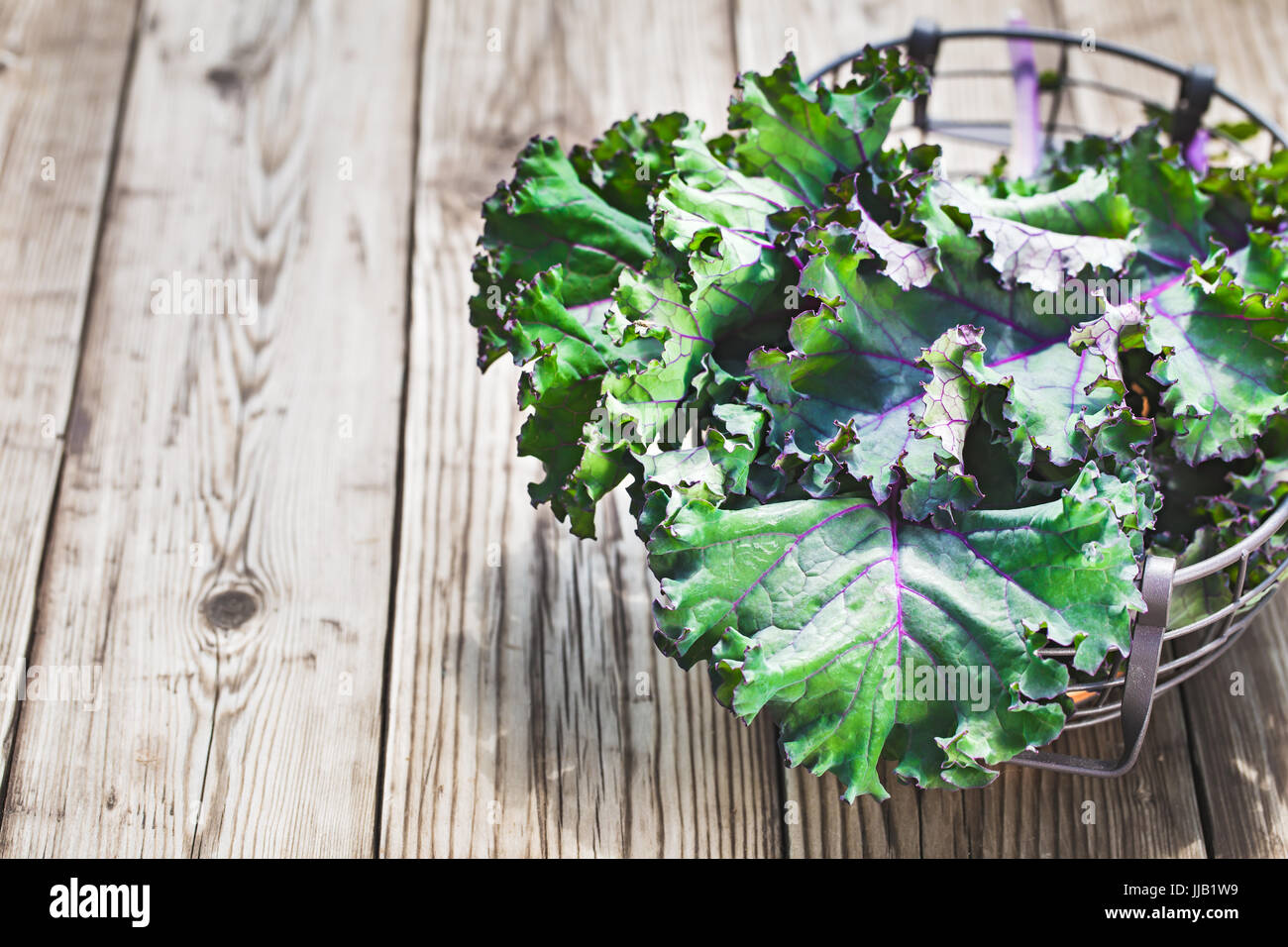 Red kale leaves on wooden table Stock Photo - Alamy