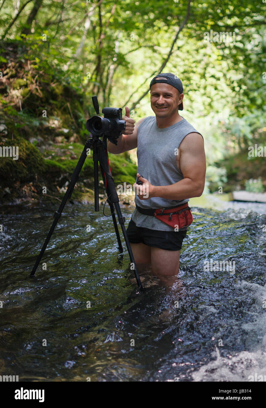 Professional photographer with camera on tripod in the middle of a cold ...